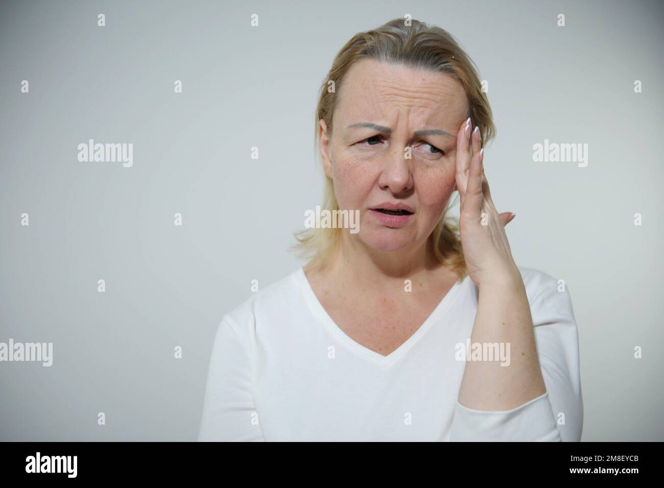 Sad tired woman touching forehead having headache migraine or ...