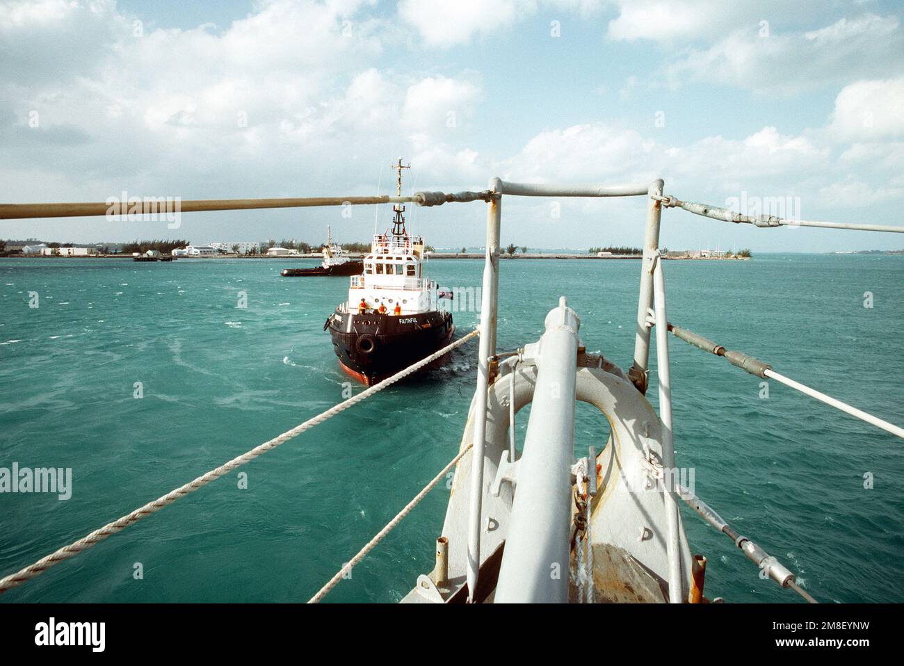The Bermudan tug boat Faithful approaches the bow of the guided missile ...