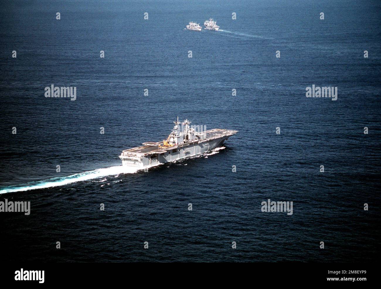 The amphibious assault ship USS Wasp (LHD-1), foreground, steams ...