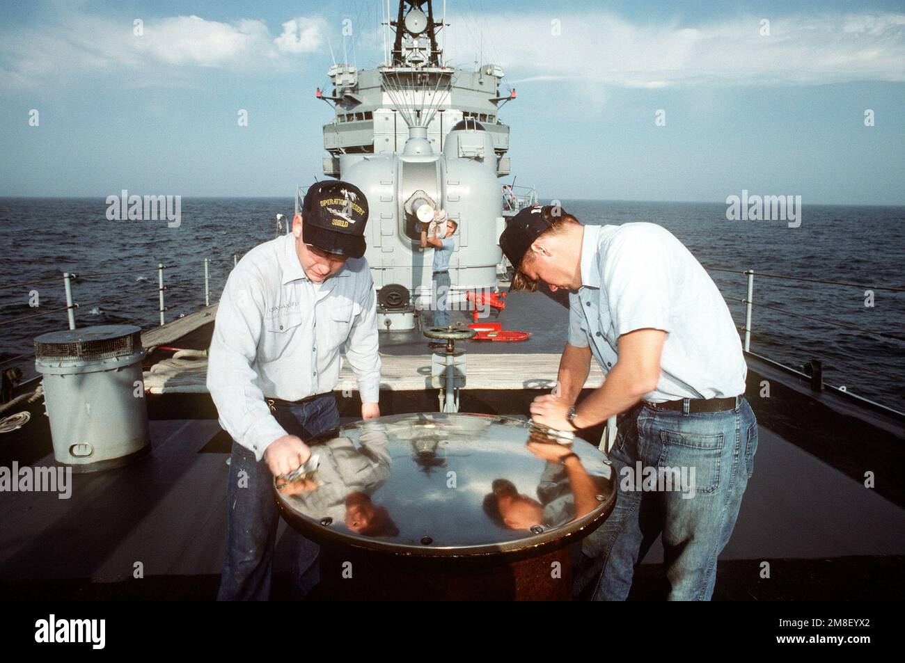 Twos sailors polish the top of a windlass aboard the guided missile ...
