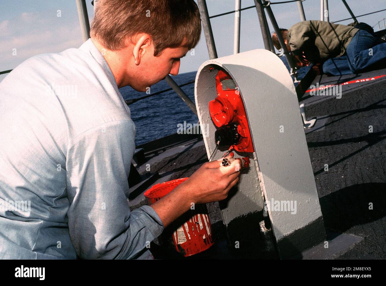 Sailors paint some of the external fittings and sufaces aboard the ...