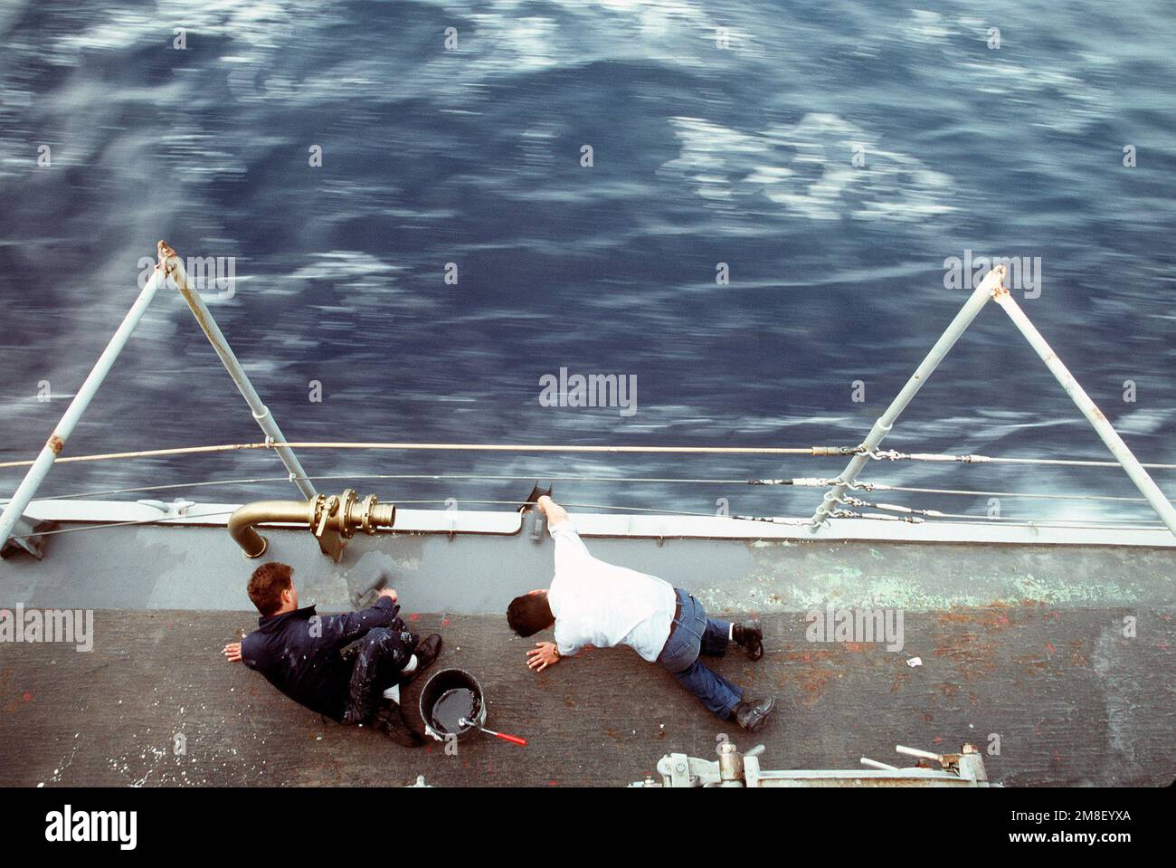Sailors paint an external section aboard the guided missile destroyer ...