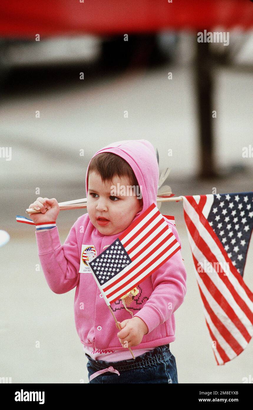 A child clutches the American flag during a ceremony to welcome home LT ...