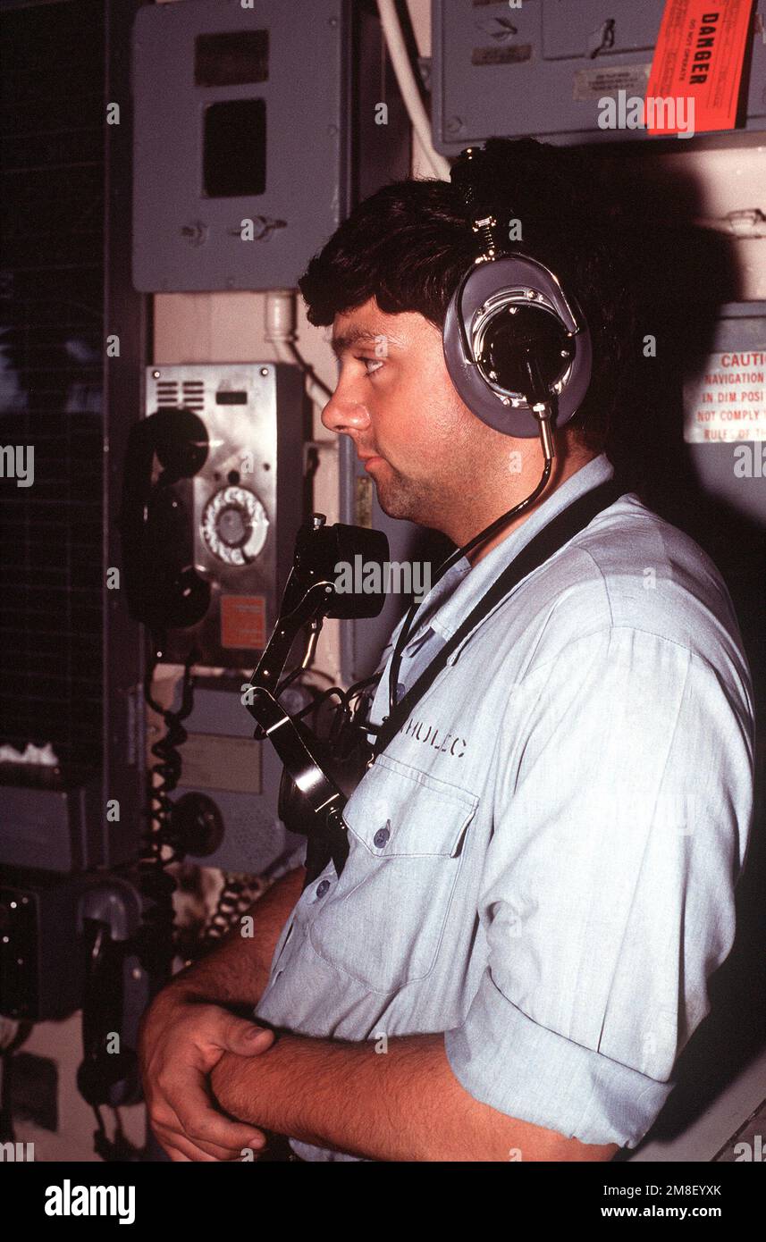 A telephone talker stands watch on the bridge of the guided missile ...