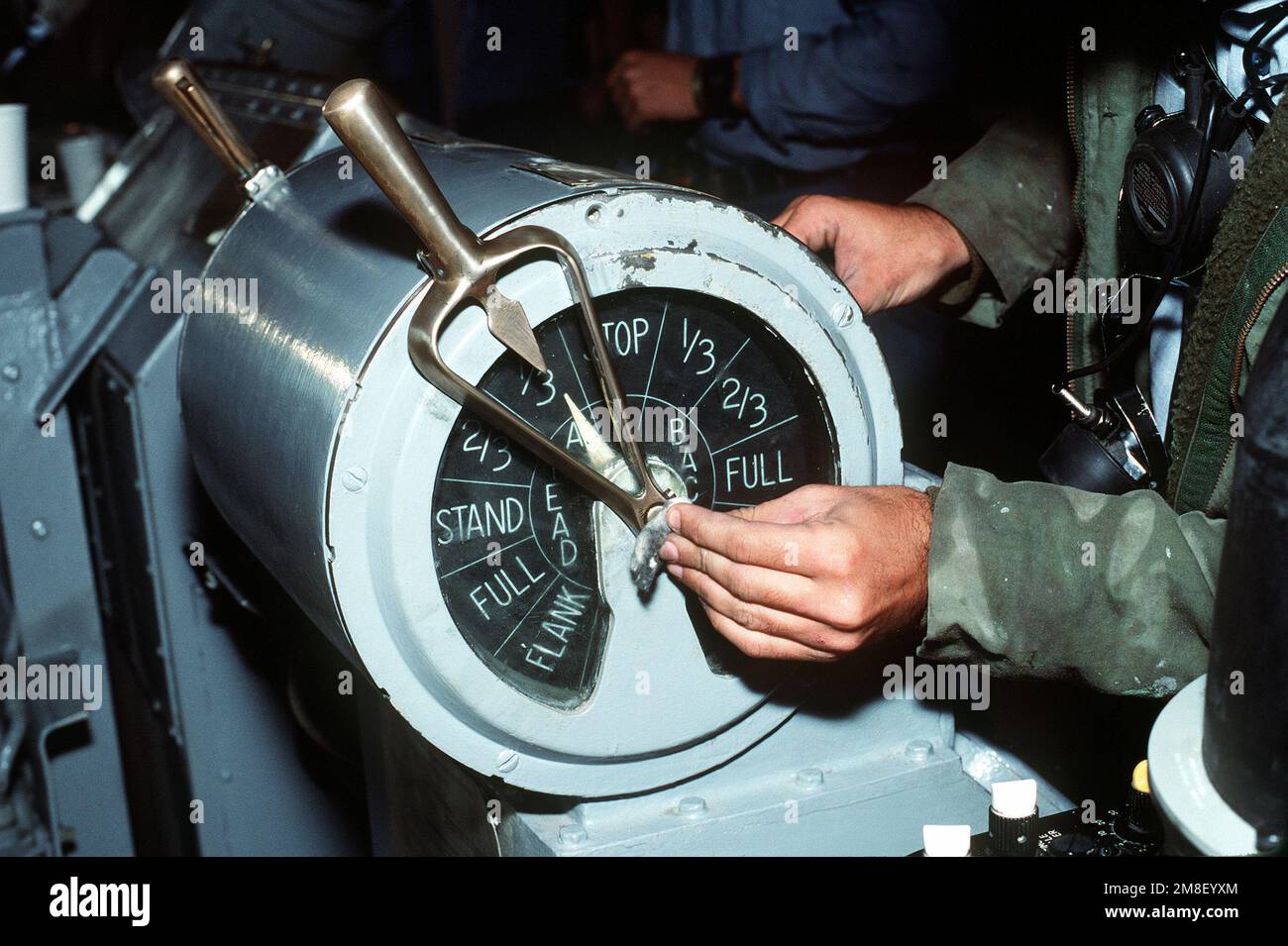 The Lee helmsman polishes the brass on the engine order telegraph while ...