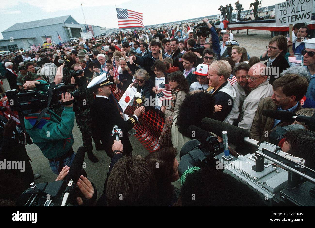 A crowd of well-wishers greets LT. Lawrence Slade following a ceremony ...