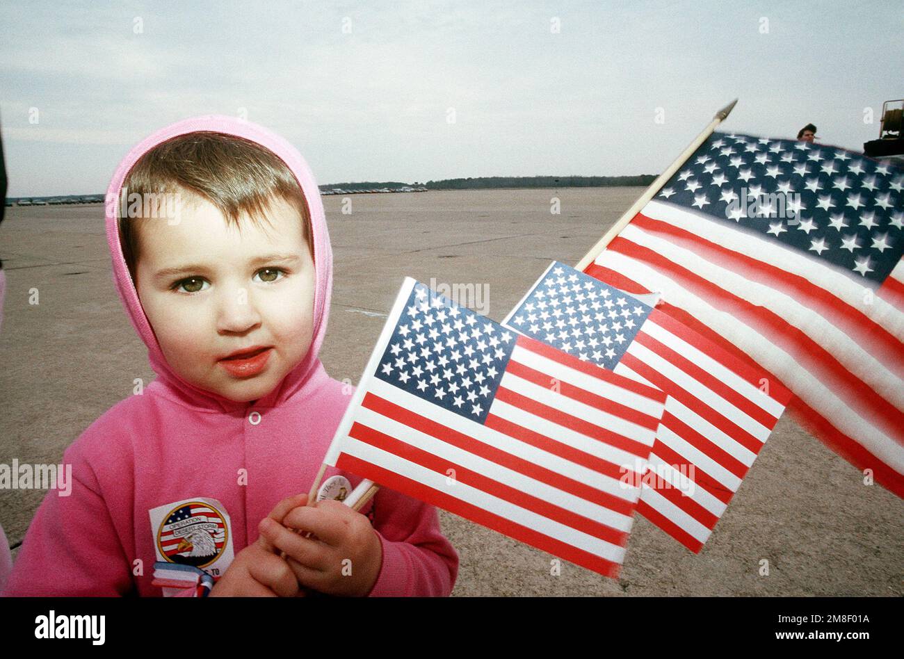 A child clutches the American flag during a ceremony to welcome home LT ...