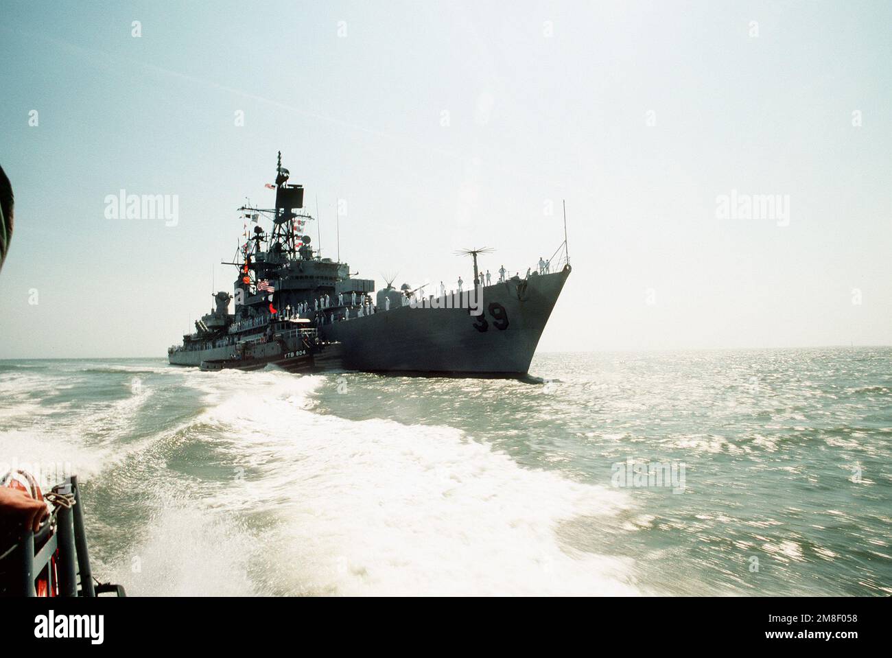 Crewmen man the rails of the guided missile destroyer USS MACDONOUGH ...