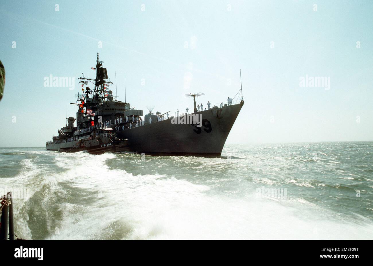 The large harbor tug AHOSKIE (YTB-804) comes alongside the guided ...