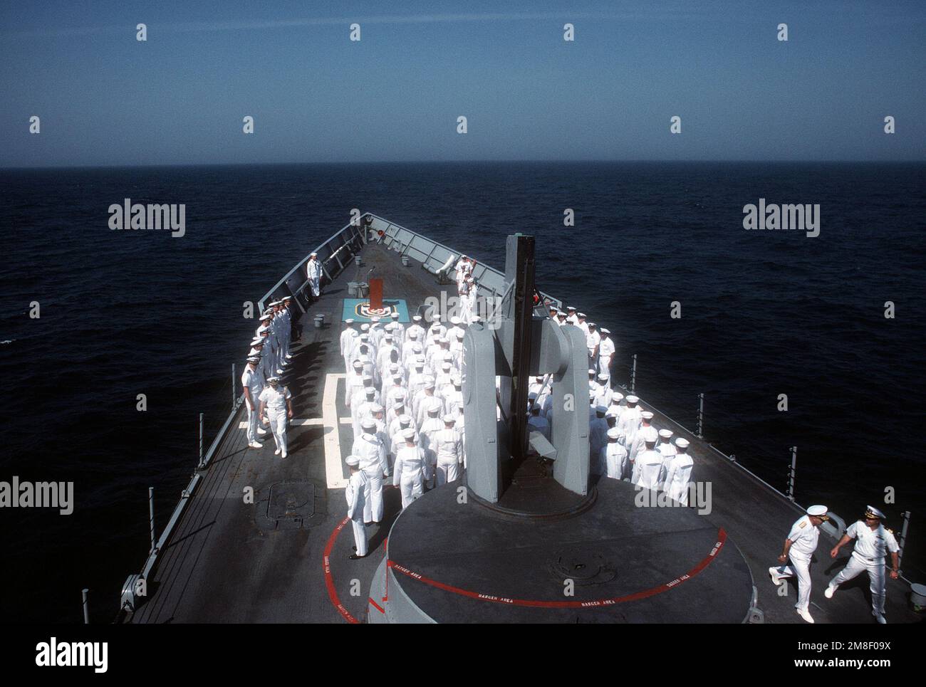 The crew of the guided missile frigate USS NICHOLAS (FFG-47) stands at ...