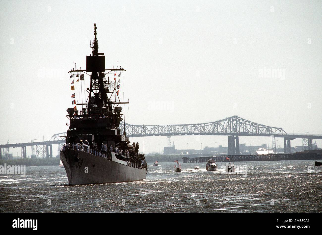 Followed by several small craft, the guided missile destroyer USS ...