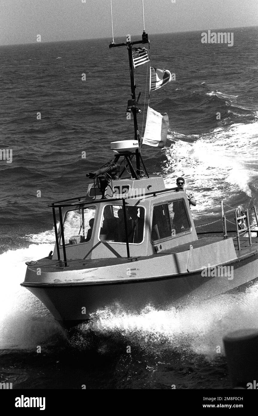 A small boat comes alongside the guided missile frigate USS NICHOLAS ...