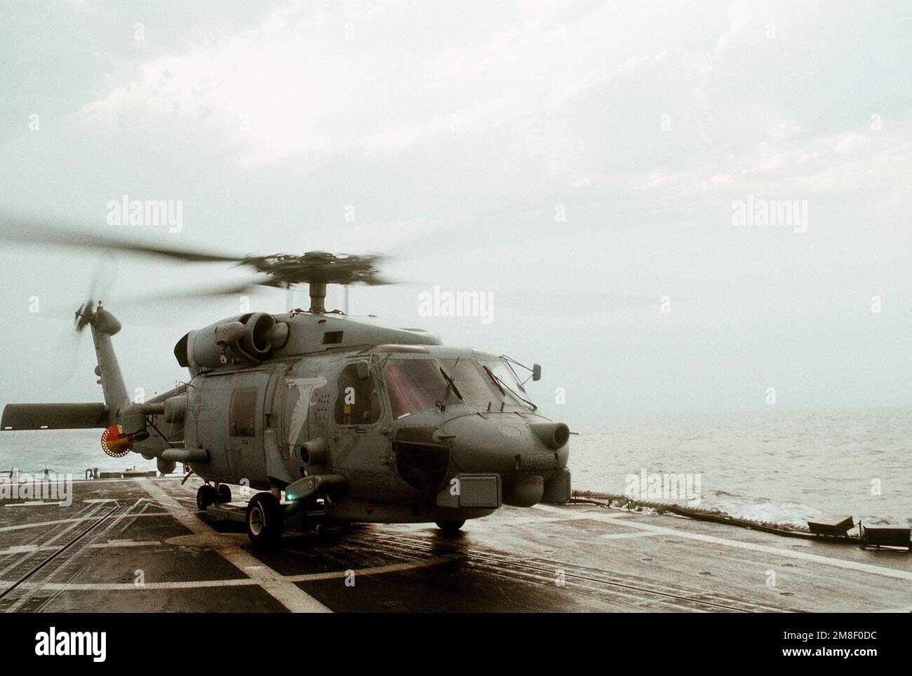 An SH-60B Sea Hawk helicopter idles on the flight deck of the guided ...