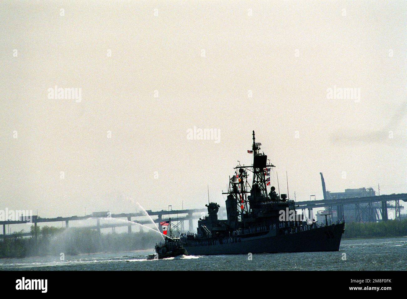 The large harbor tug ESCORTS the guided missile destroyer USS ...