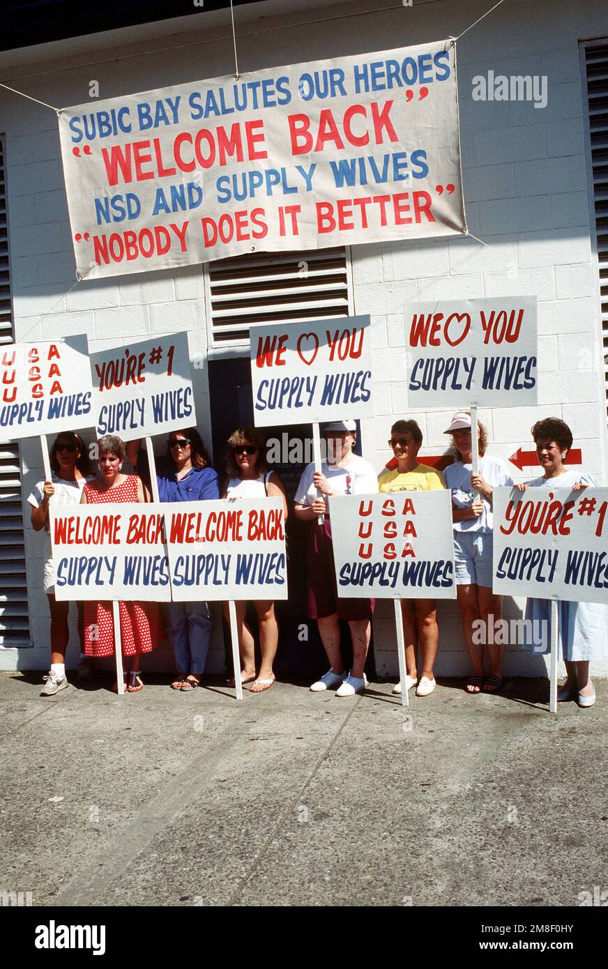Members of a base women's organization wait with their signs and ...