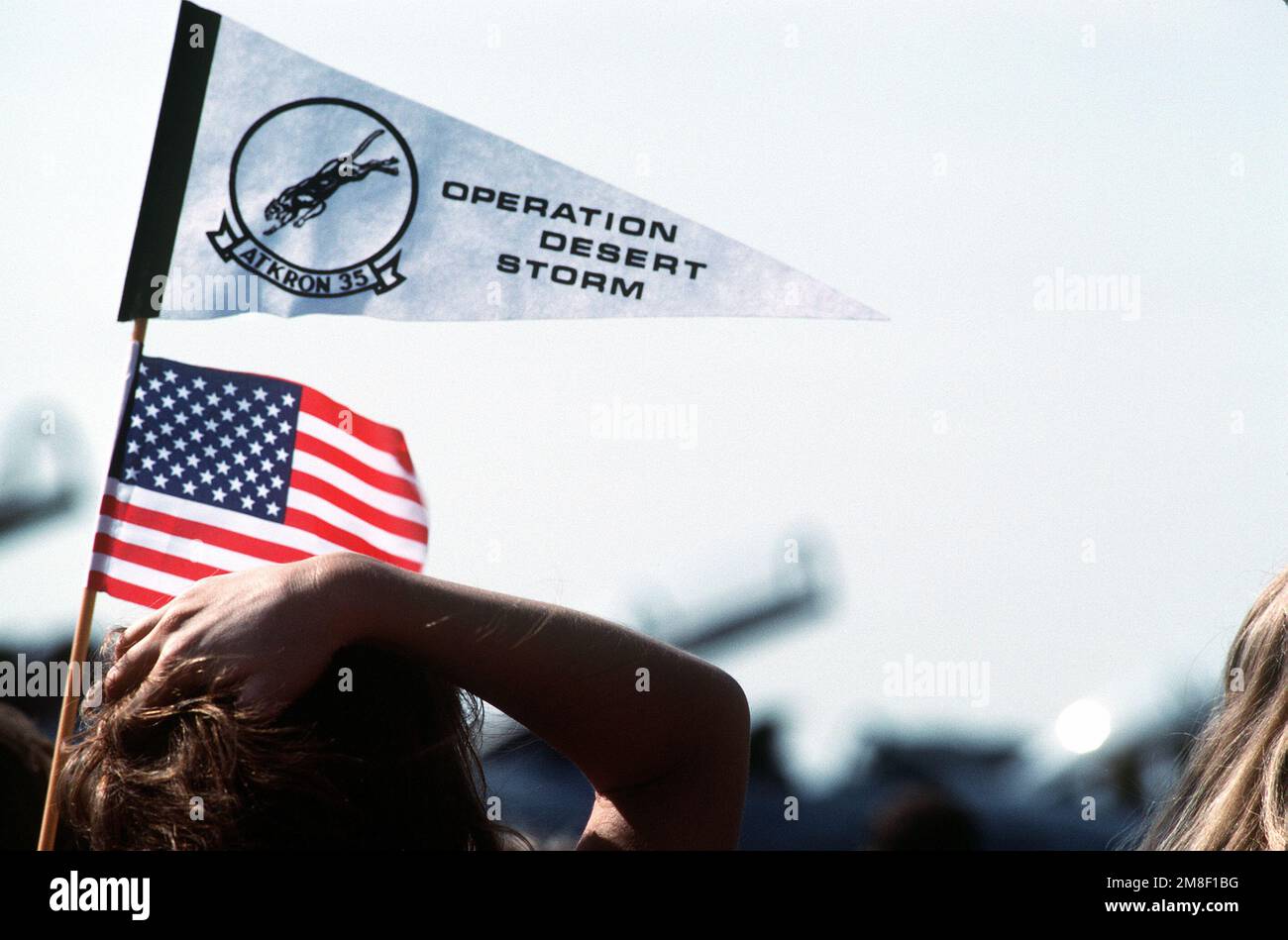 A spectator holds an Attack Squadron 35 (VA-35) banner and American ...