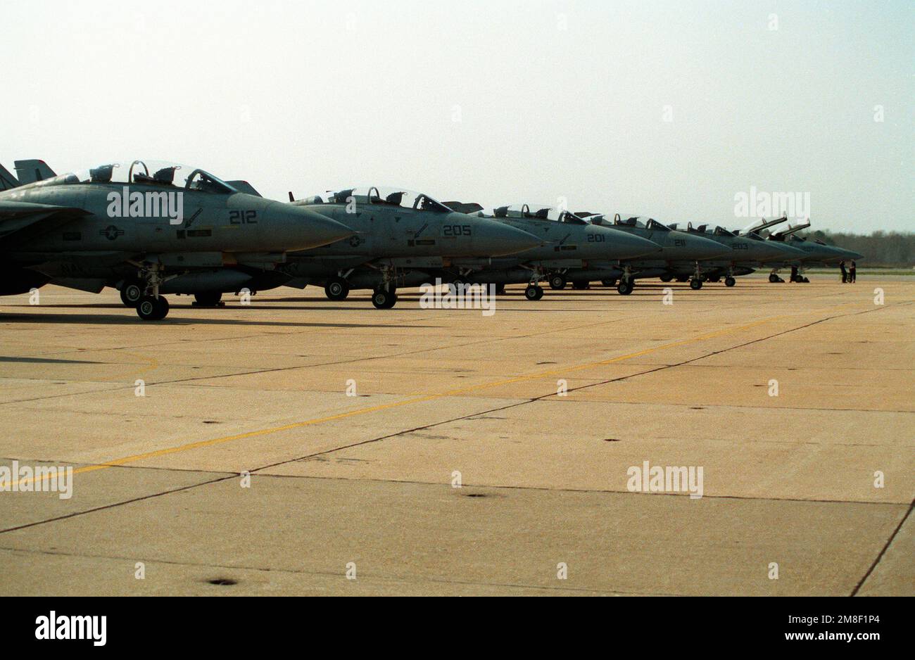 The F-14A Tomcat aircraft of Fighter Squadron 103 (VF-103) sit wing-to-wing on the flight line ...
