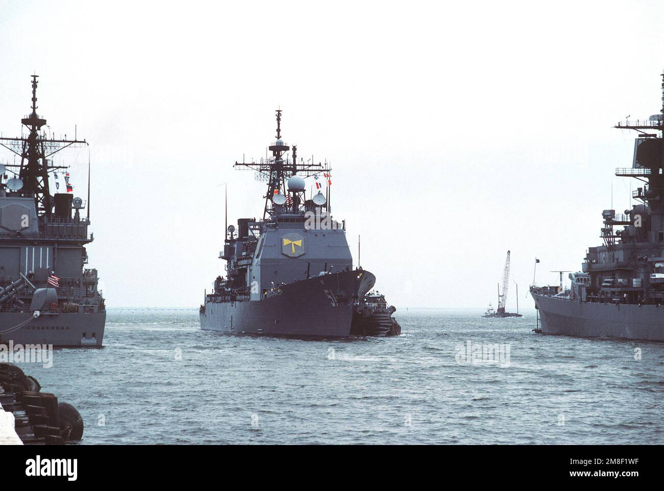 The large harbor tug Anoka (YTB-810) assist the guided missile cruiser ...