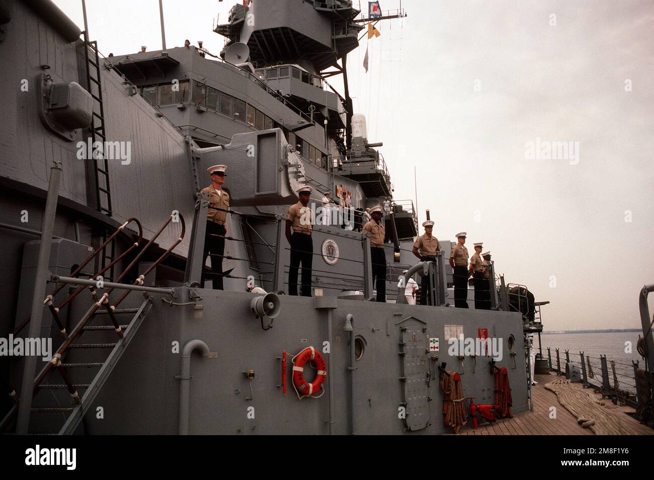 Members of the Marine detachment man a rail of the battleship USS ...