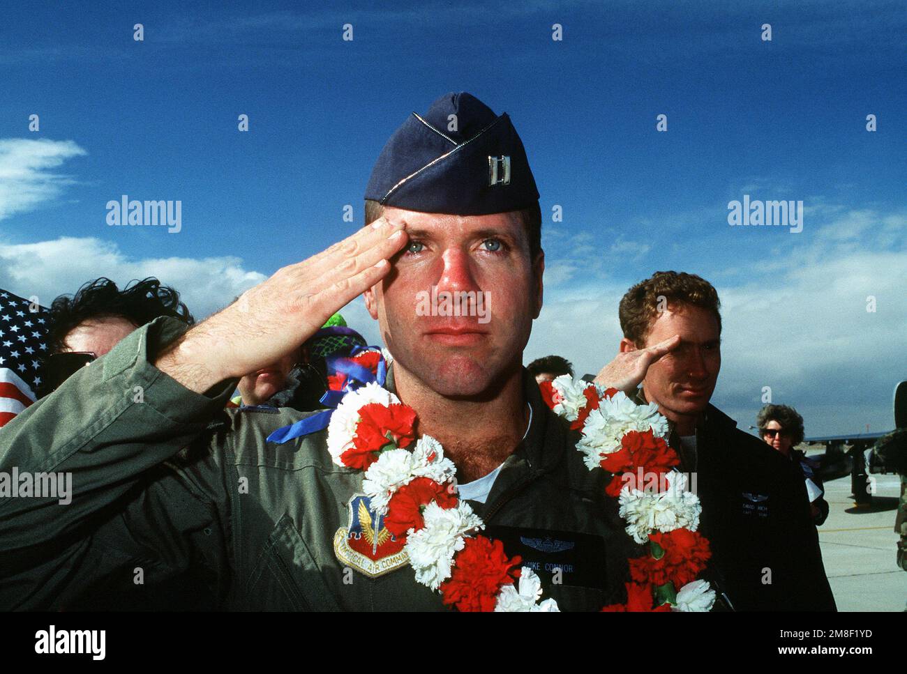 CAPT. Mike Connor and other members of his unit salute the colors upon ...