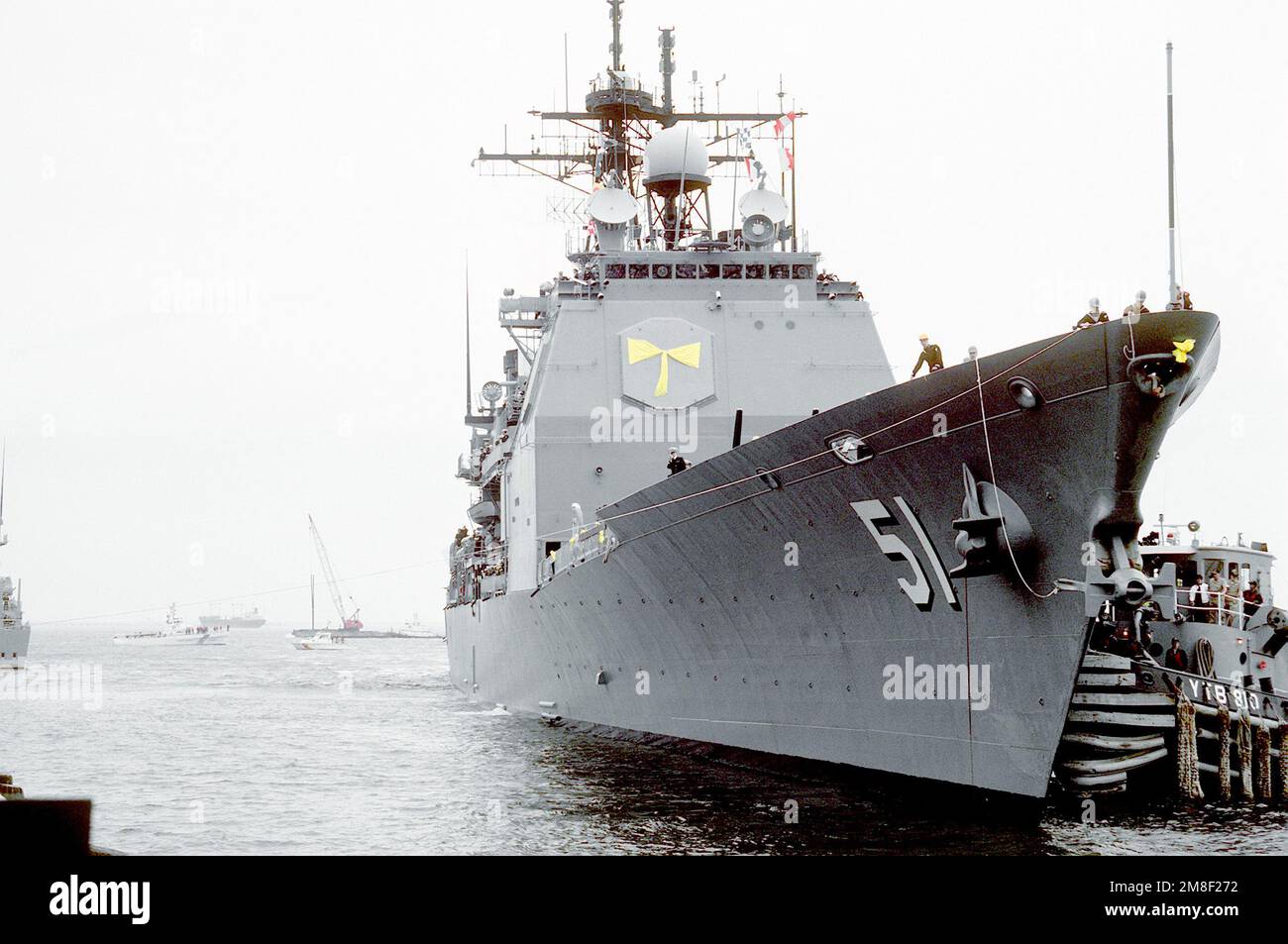 The large harbor tug ANOKA (YTB-810) pushes against the bow of the ...