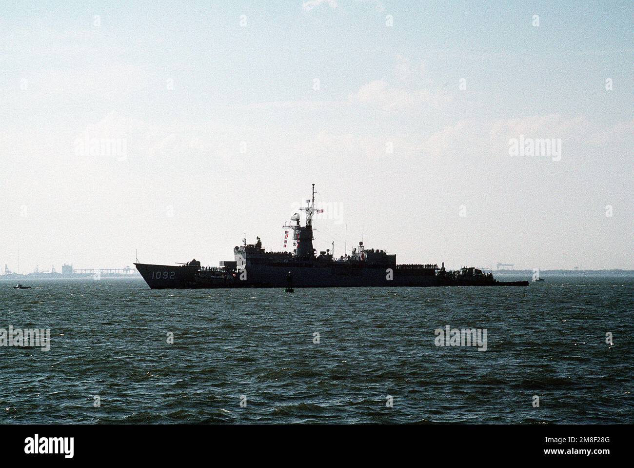 Two large harbor tugs accompany the frigate USS THOMAS C. HART (FF-1092 ...