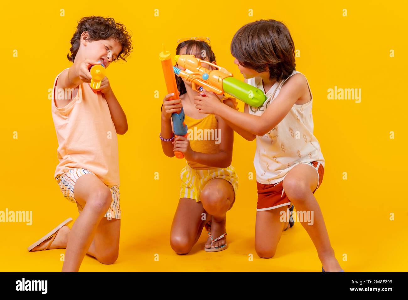 Kids having fun with water pistols on summer vacations and aiming at ...