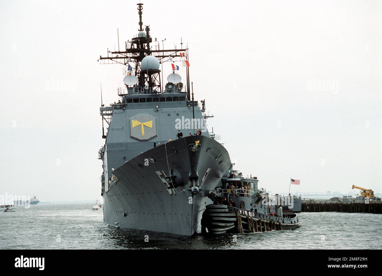 The large harbor tug ANOKA (YTB-810) pushes against the bow of the ...