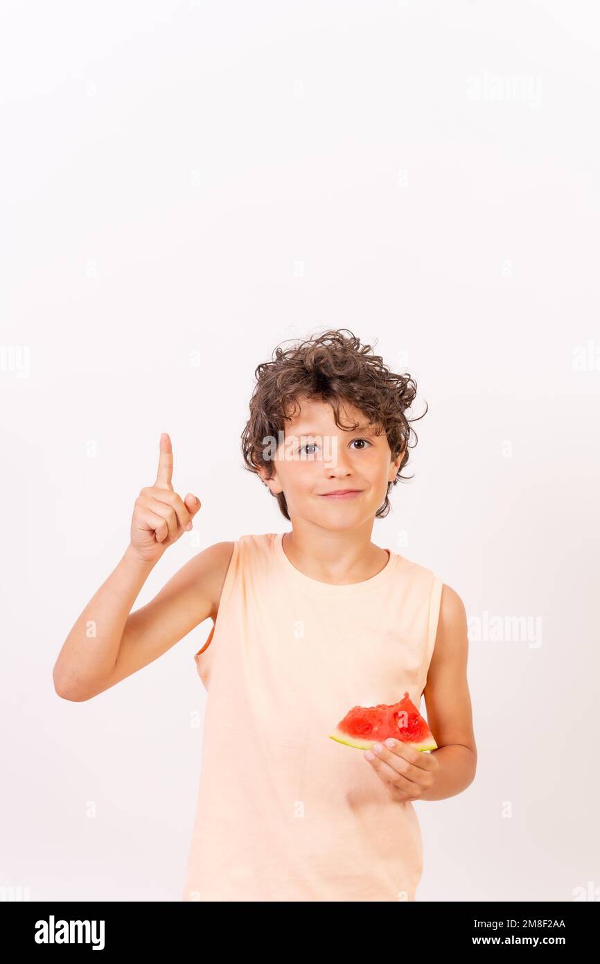 Boy eating a watermelon and pointing up, summer vacation. White ...