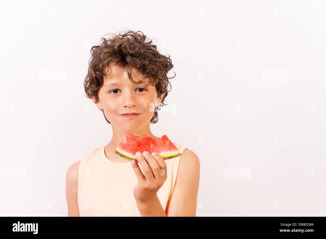 Boy enjoying the summer eating a watermelon, school vacation concept ...