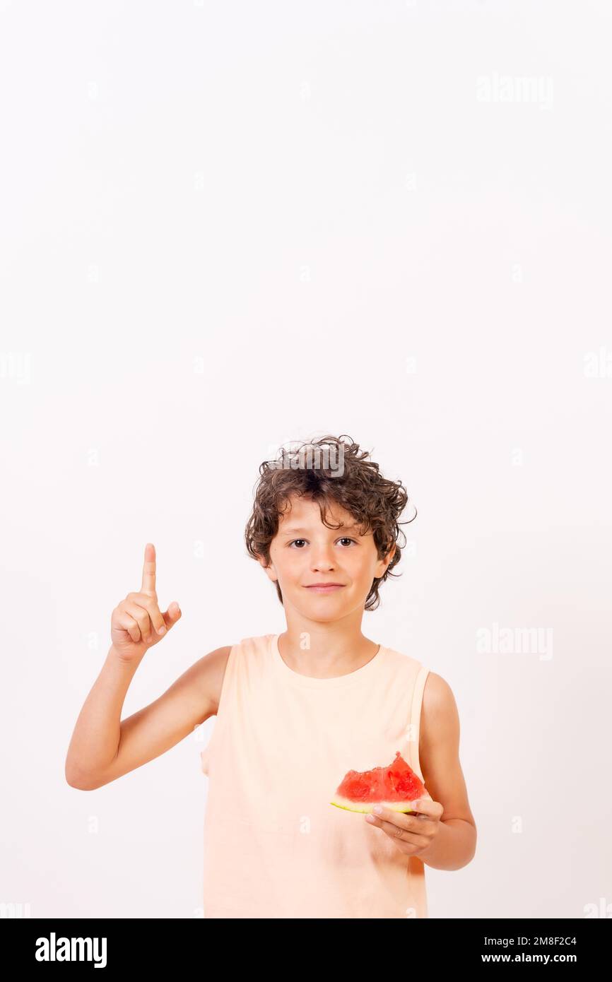 Boy eating a watermelon and pointing up, summer vacation. White ...