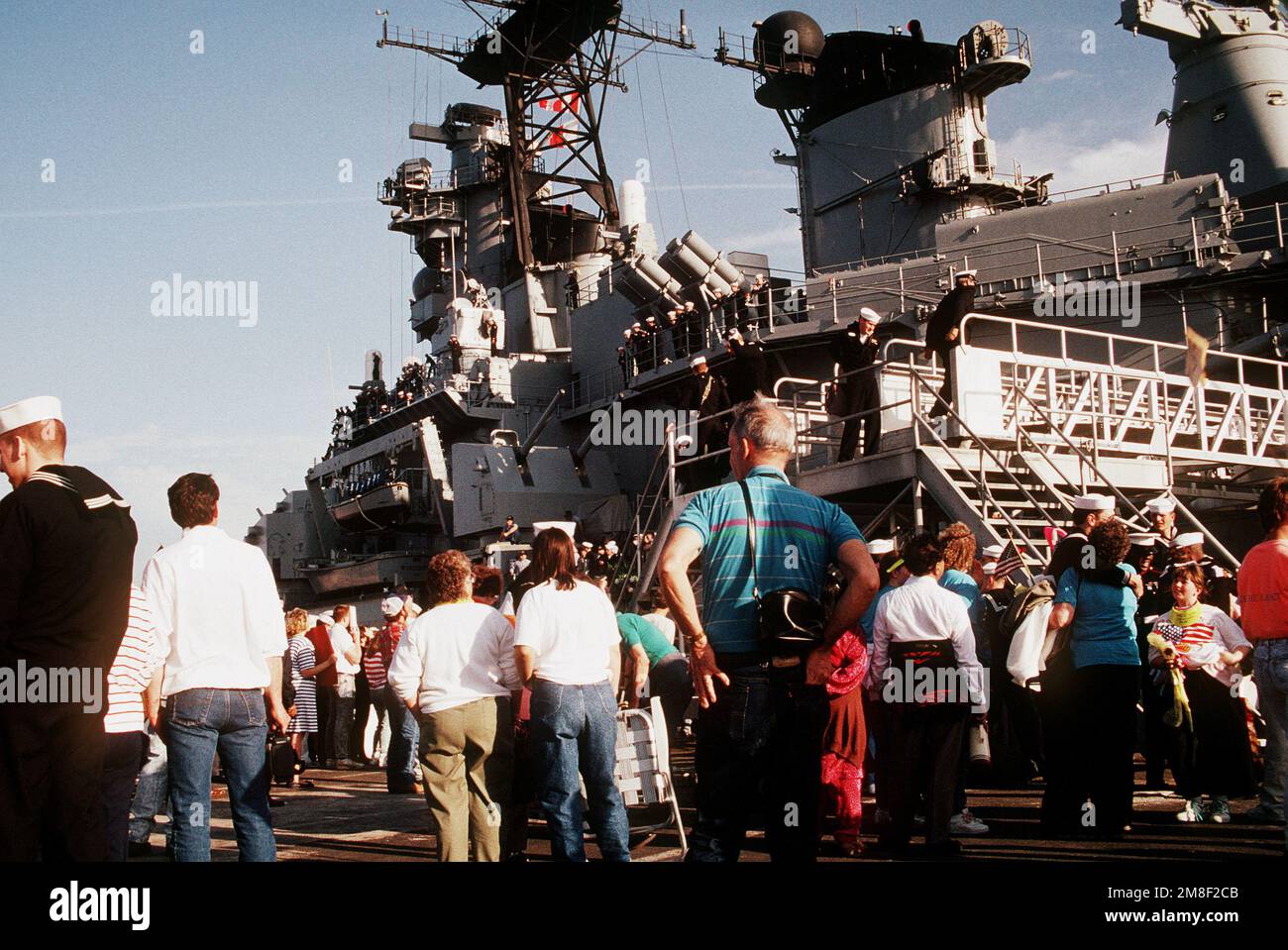 Family members and friends wait on the pier as crew members disembark ...