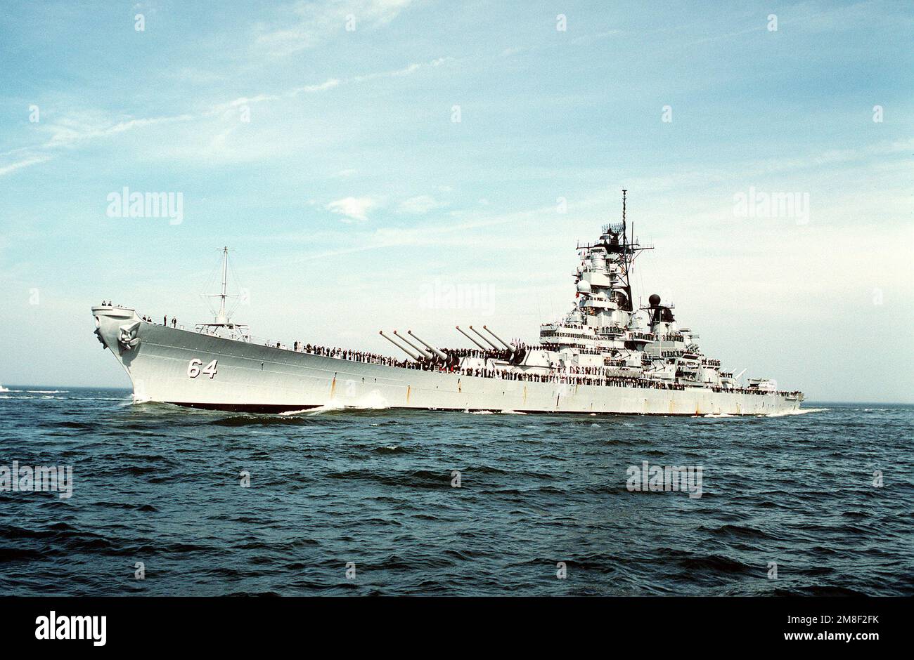 A port bow view of the battleship USS WISCONSIN (BB-64) with sailors ...