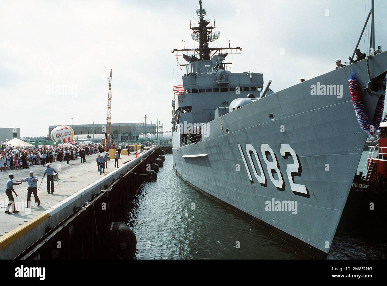 Sailors on the pier handle mooring lines as the frigate USS ELMER ...