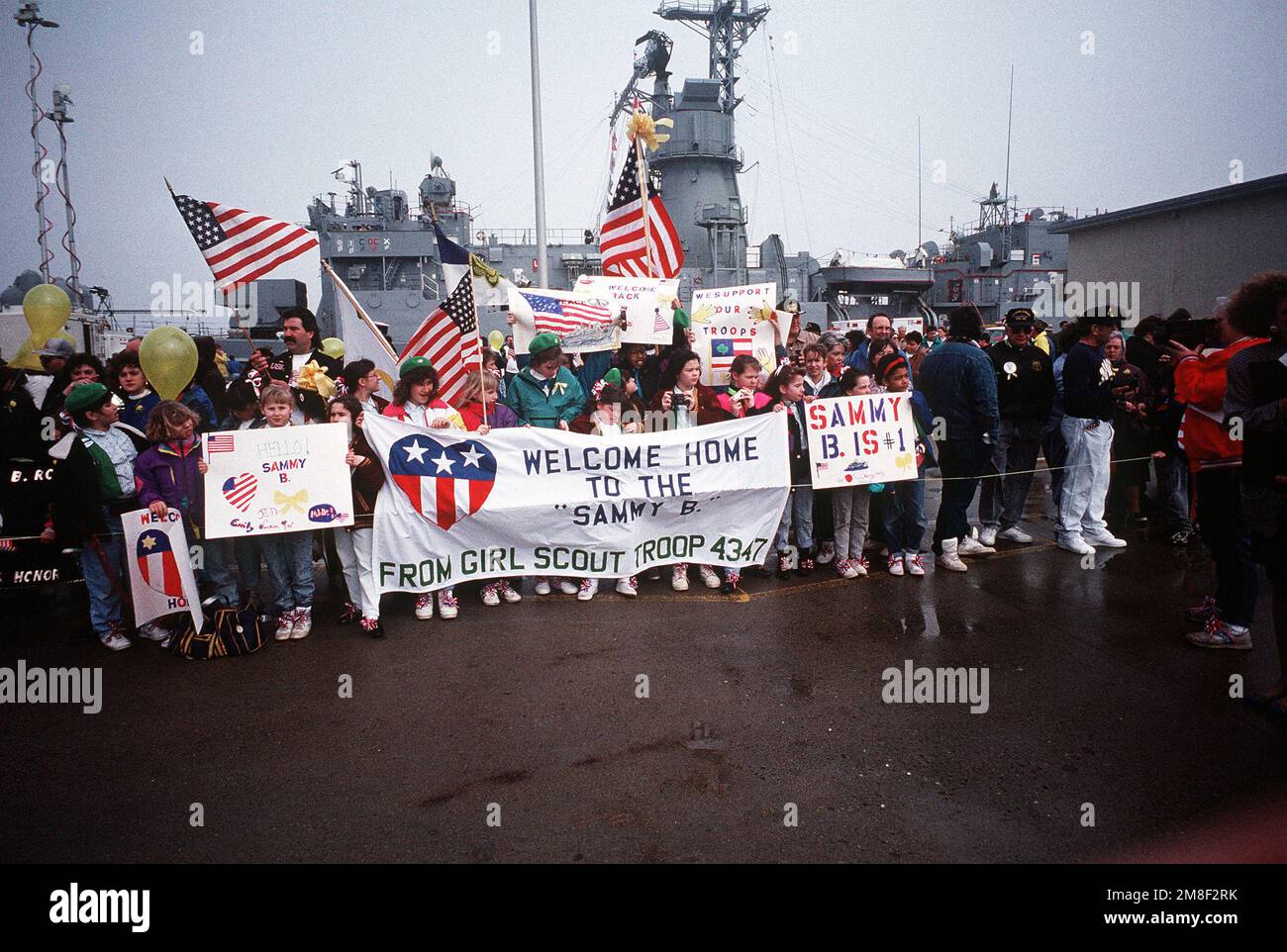 Members of a local girl scout troop hold a banner welcoming the crew of ...