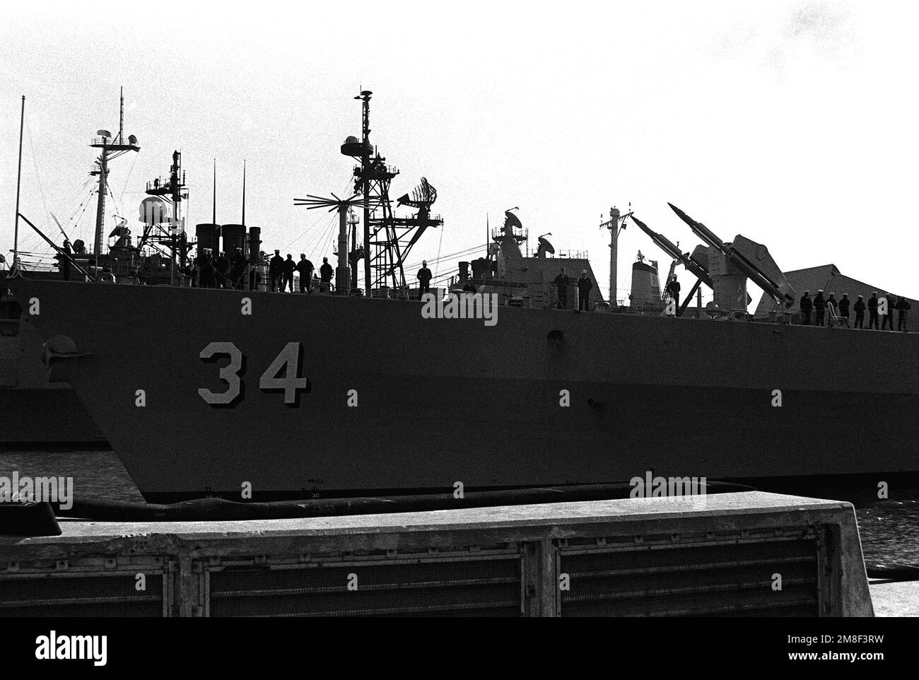 Line handlers stand at parade rest aboard the guided missile cruiser ...
