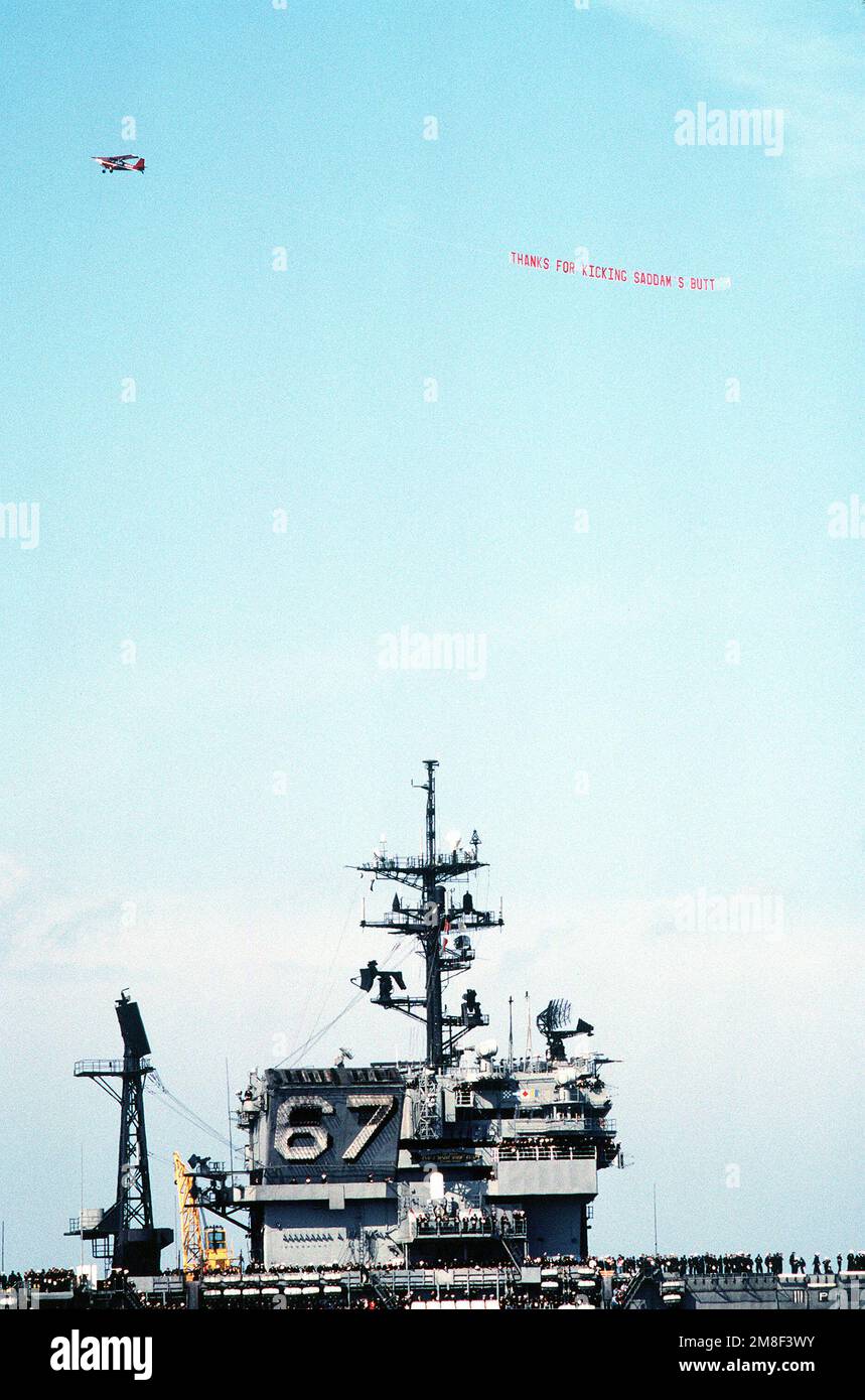 Sailors stand at the railing on the island of the aircraft carrier USS ...