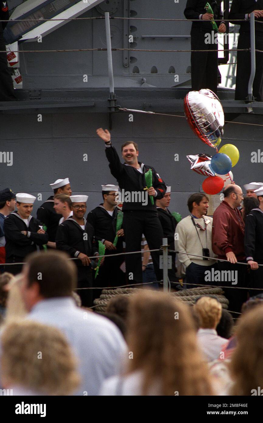 A sailor waves to his loved ones upon his arrival at the station aboard ...