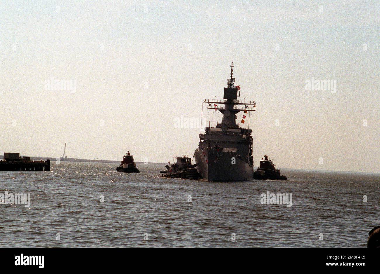 Large harbor tugs maneuver the nuclear-powered guided missile cruiser ...