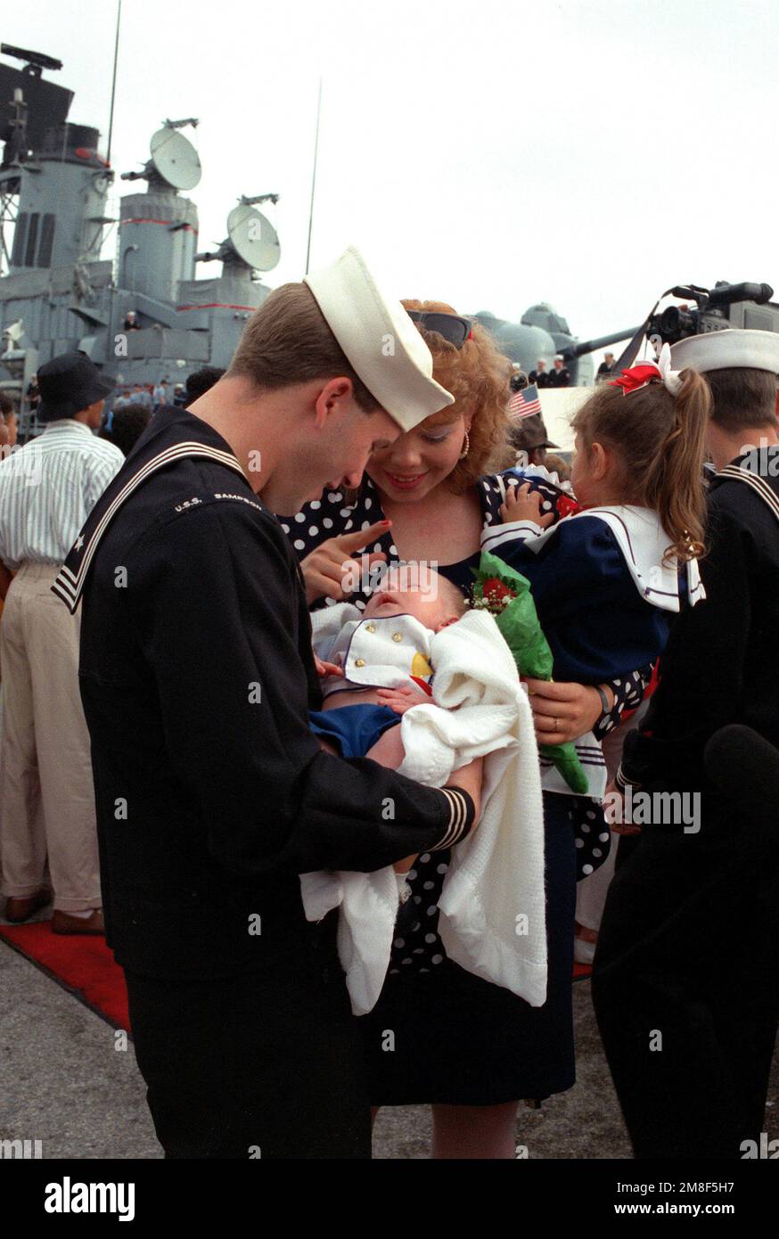 A sailor from the guided missile destroyer USS SAMPSON (DDG-10) holds ...