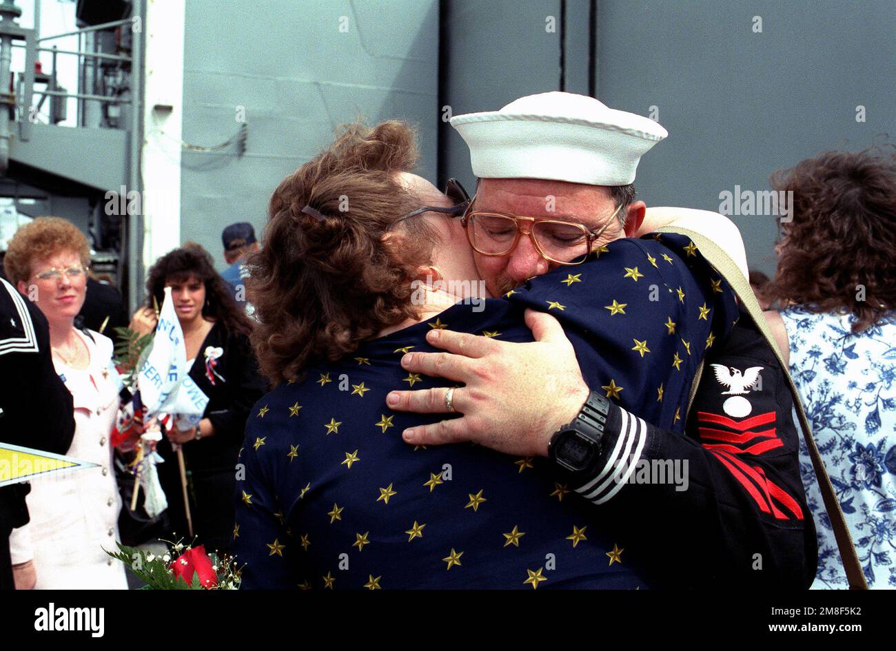 A petty officer embraces his wife as they are reunited aboard the ...