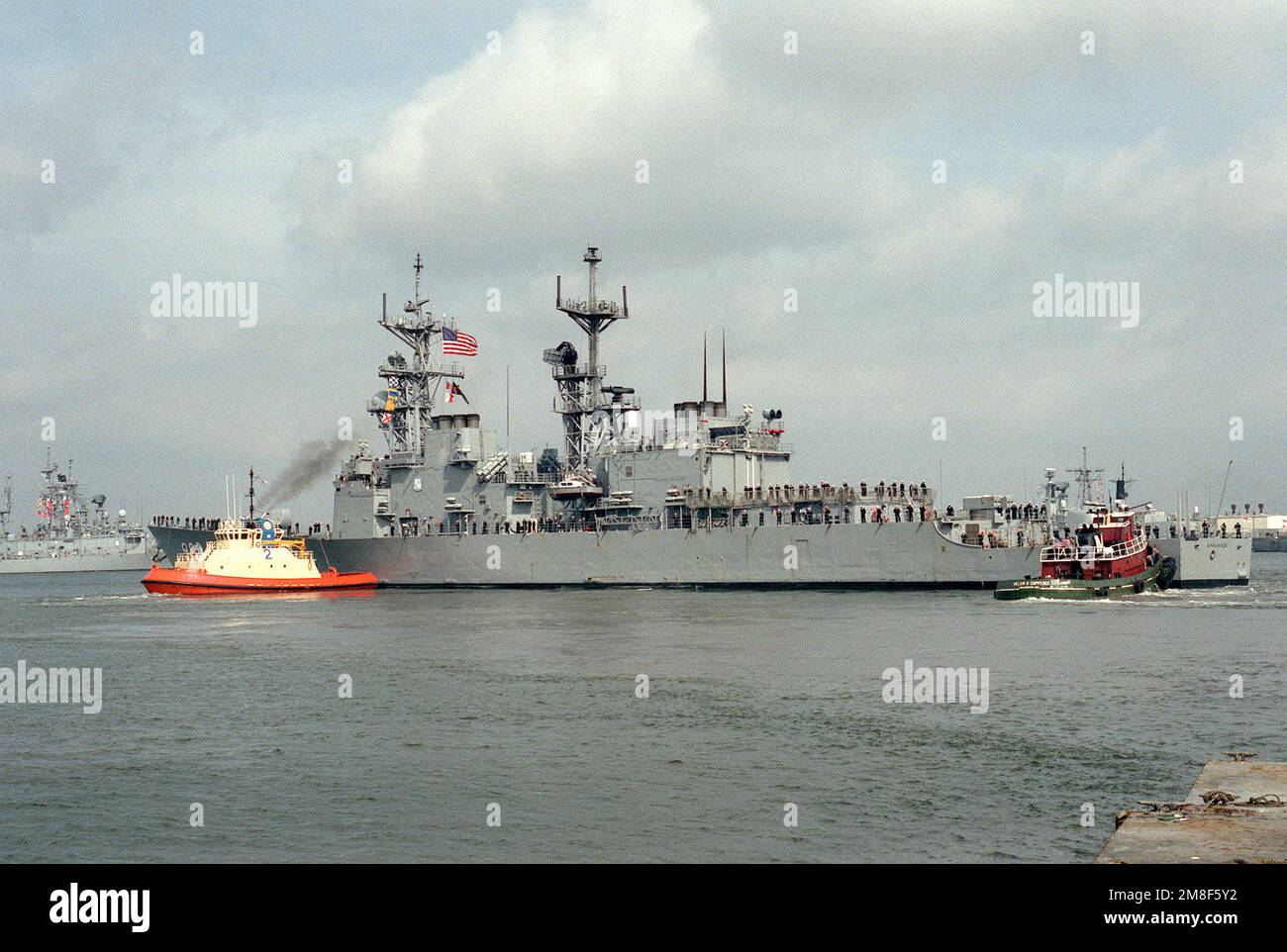 Tug boats push the destroyer USS SPRUANCE (DD-963) into place alongside ...