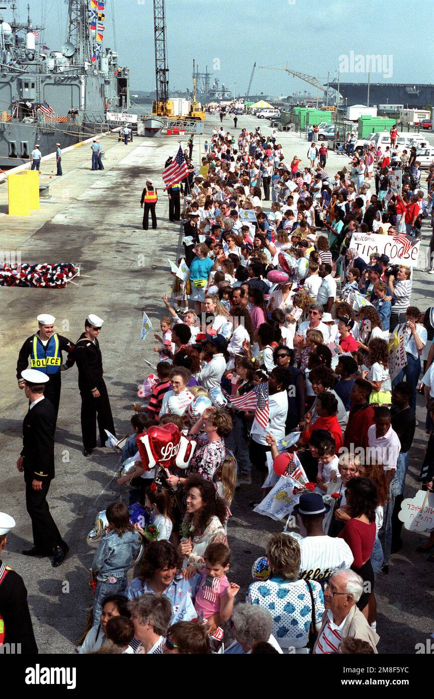 Friends and family members line up along the pier to welcome home their ...