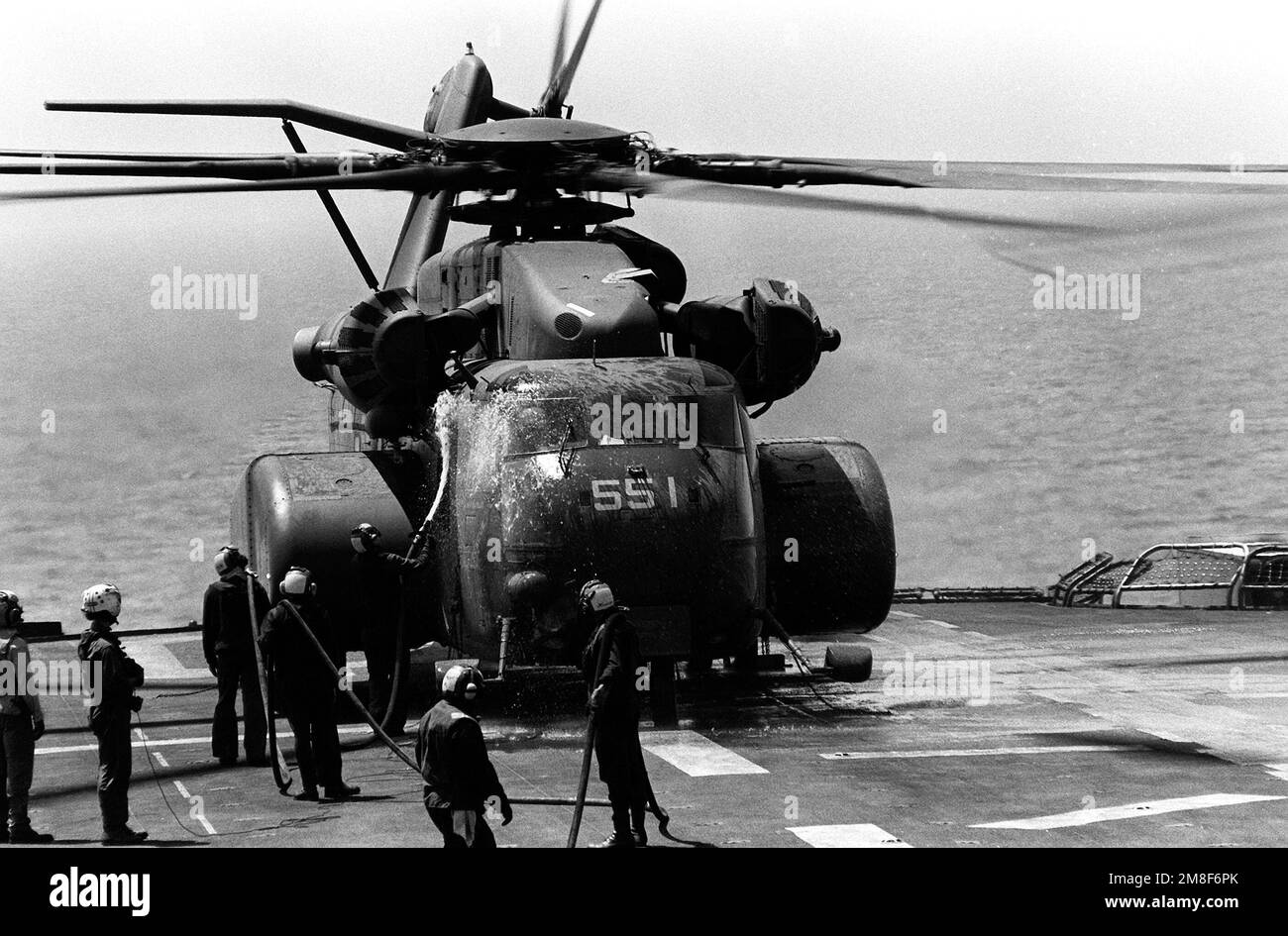 Flight deck crewmen wash down a Helicopter Mine Countermeasures ...