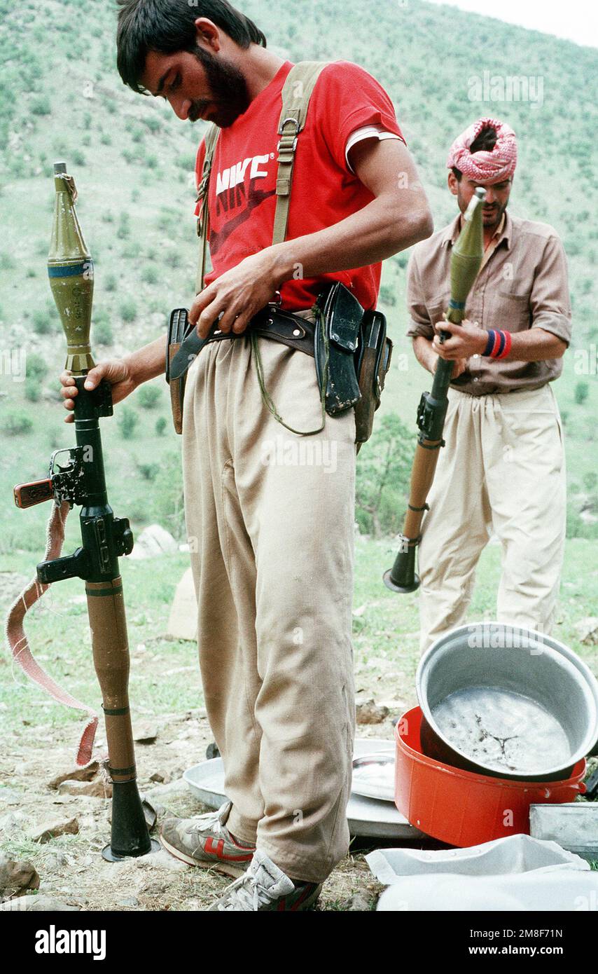 Kurdish refugees carry RPG-7 portable rocket launchers as they prepare ...