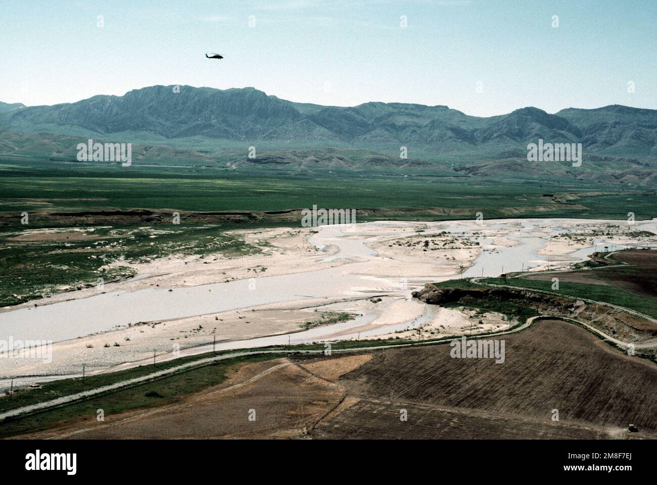 A UH-60 Black Hawk helicopter flies over the Tigris River on the border ...