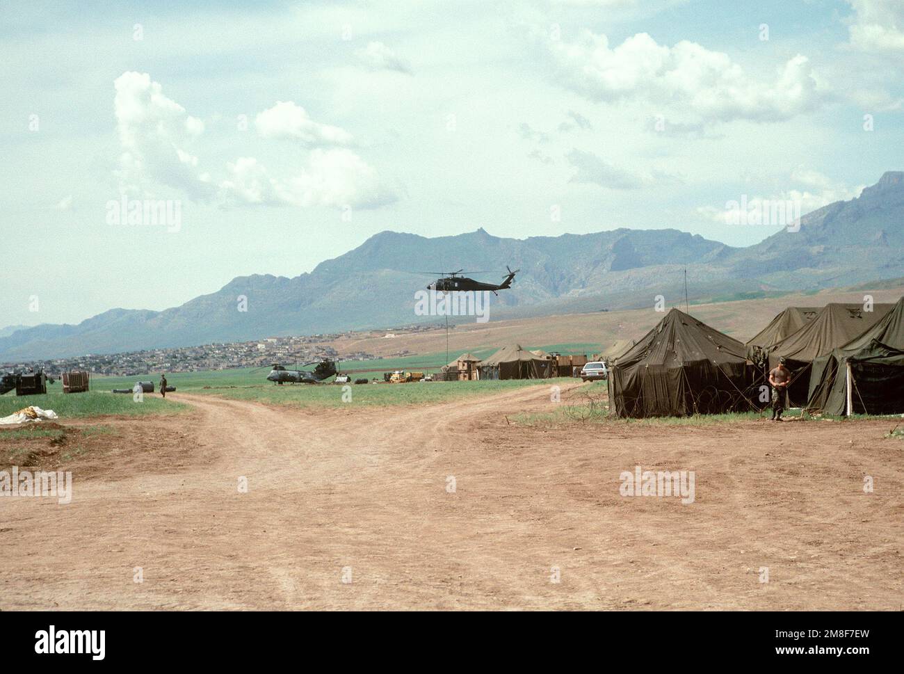 A U.S. Army UH-60 Black Hawk (Blackhawk) helicopter takes off as a CH ...