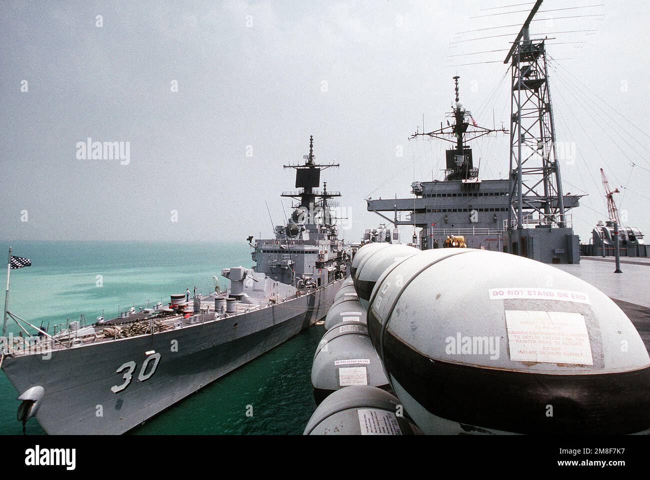 The guided missile cruiser USS HORNE (CG-30) sits at anchor beside the ...