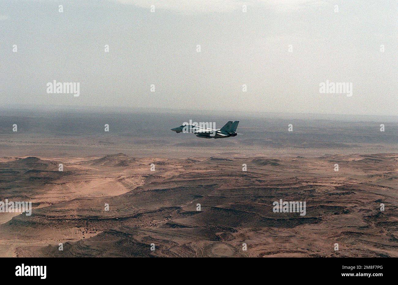 A Fighter Squadron 41 (VF-41) F-14A Tomcat aircraft flies over some ...
