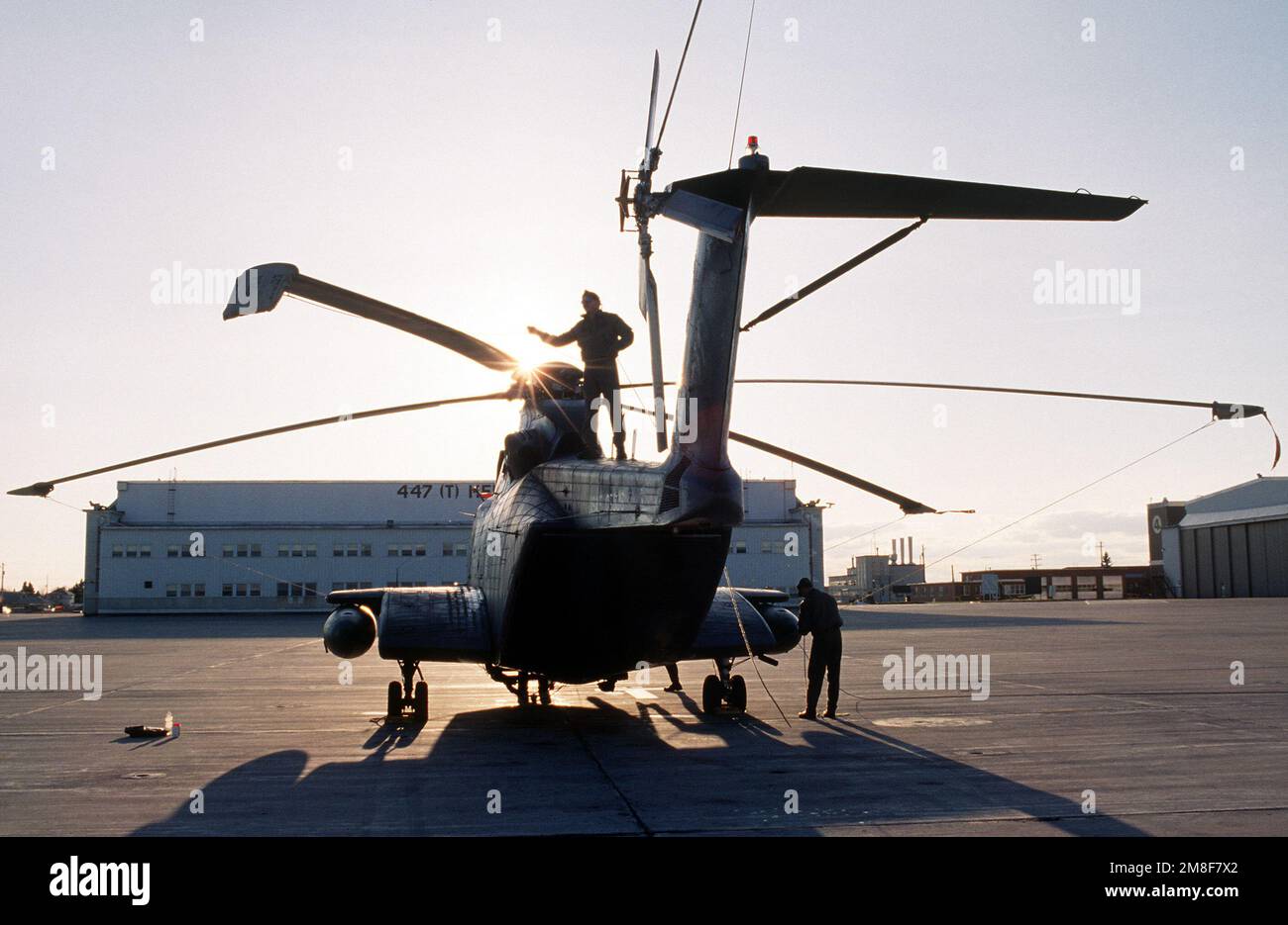 A helicopter crew member stands atop a 71st Air Rescue Squadron (71st ...